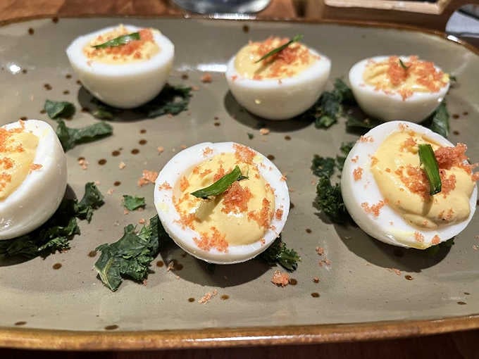 Six deviled eggs dusted with crispy chicharron, lined up like the most delicious little soldiers you've ever met.
