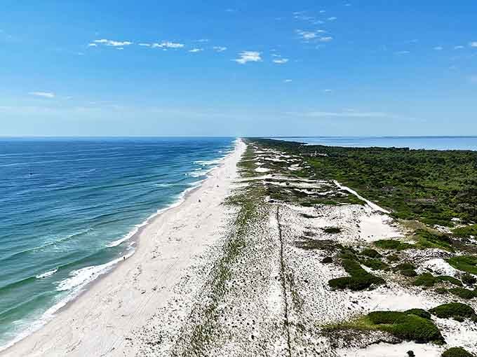 Aerial perspective reveals the stunning barrier island geography, ocean on one side, bay on the other, pure magic.