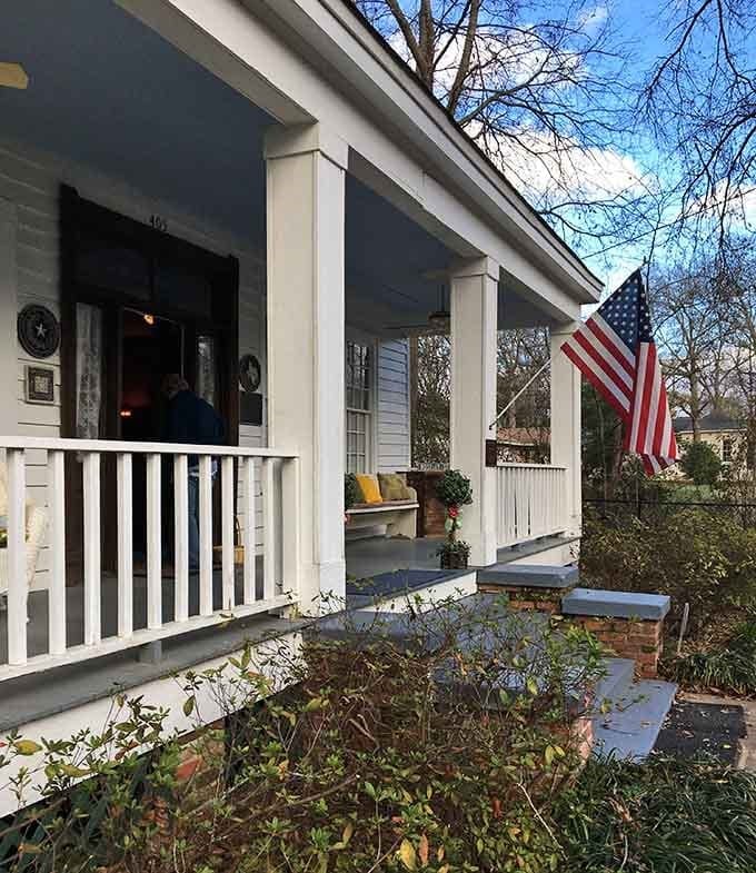 A wraparound porch with an American flag flying proud, the kind of front yard that makes you want to stay awhile.