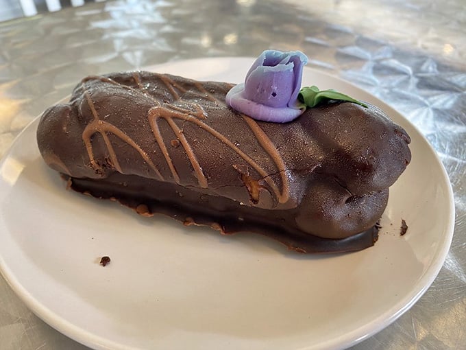 That chocolate eclair with its delicate purple flower garnish is almost too pretty to eat, but you absolutely should.