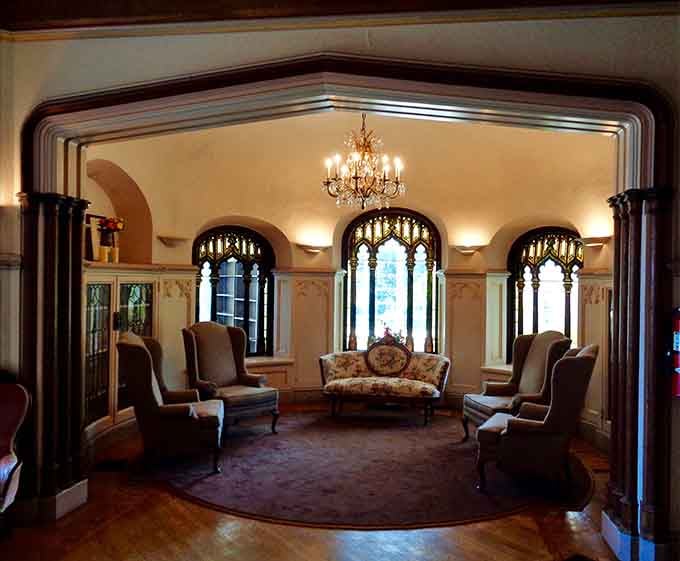 Wingback chairs, a chandelier, and Gothic arched windows. This parlor room means serious business about being absolutely gorgeous.