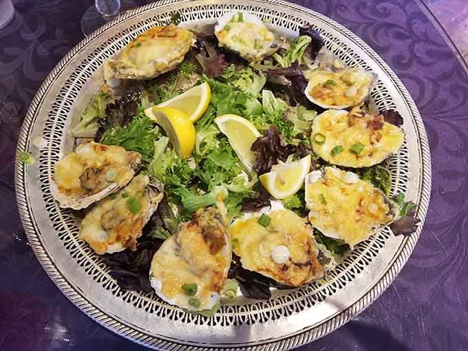 Oysters Bienville on a silver platter, bubbling with cheese and creole sauce. Pure, unapologetic indulgence.