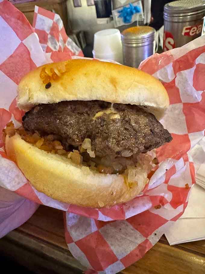 Caramelized onions piled beneath a beautifully seared patty, nestled in red-checked paper, this is comfort food that means serious business.
