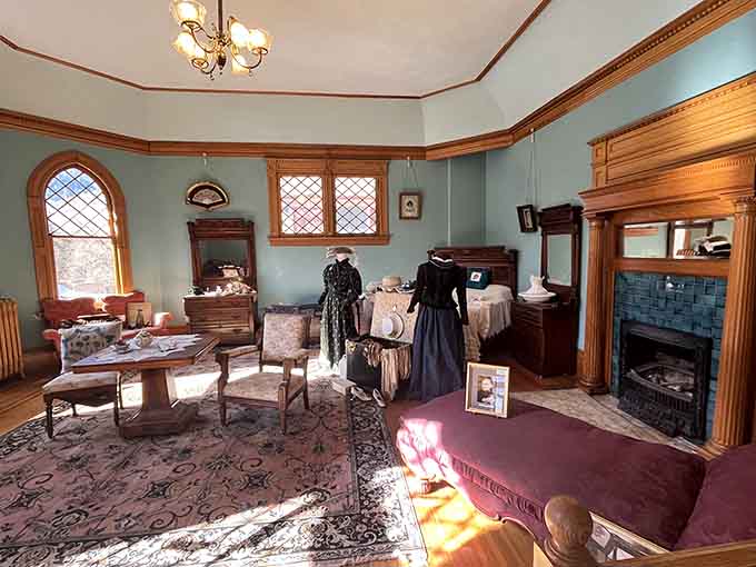 Period dresses, a tiled fireplace, and afternoon light that turns this bedroom into a genuine time machine.