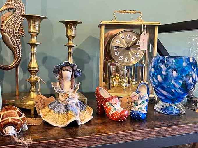 Brass candlesticks, a glass clock, painted ceramic shoes, and a cobalt vase that somehow all belong together perfectly.