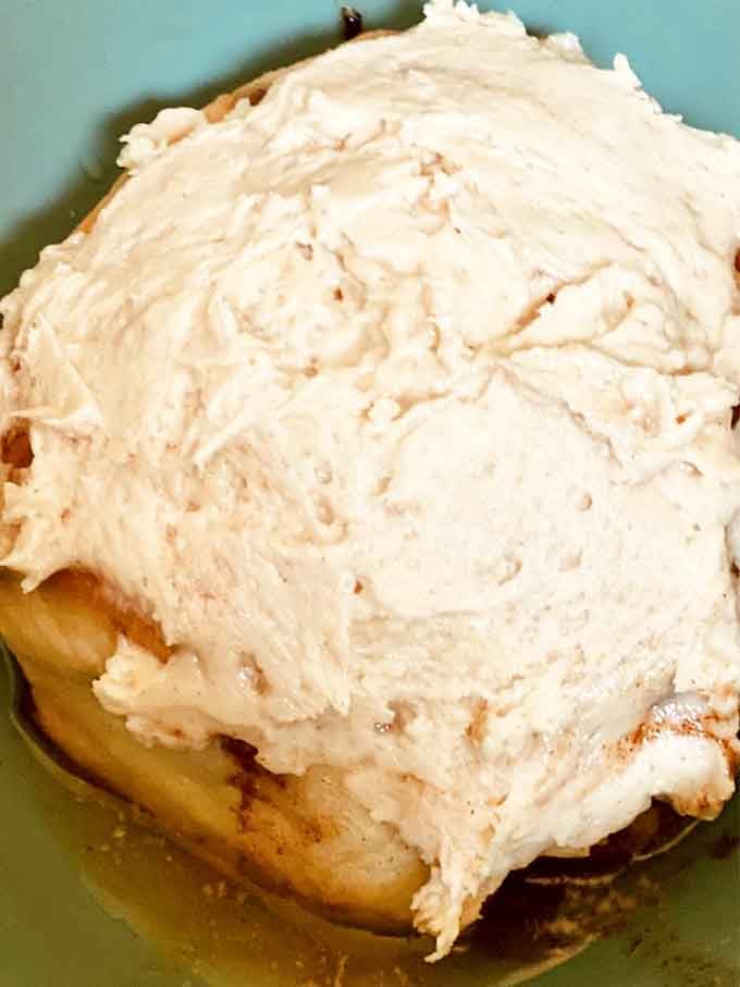 A mountain of cream cheese frosting so generous it makes every other cinnamon bun feel deeply inadequate.