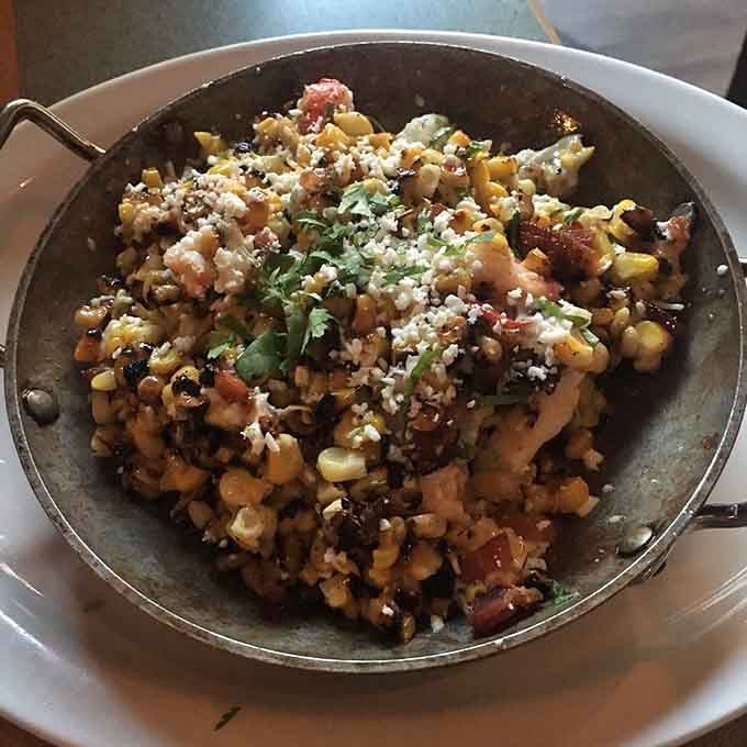 Charred corn, cotija, cilantro, and what appears to be bacon. Street corn grew up, moved to Cambridge, and never looked back.