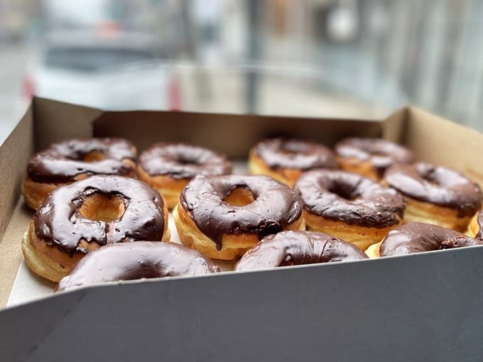 A full box of chocolate glazed donuts is basically a love letter written in dough and frosting.