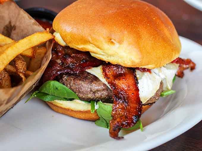 Crispy bacon, fresh greens, and melted cheese on a brioche bun, this burger means serious, delicious business.