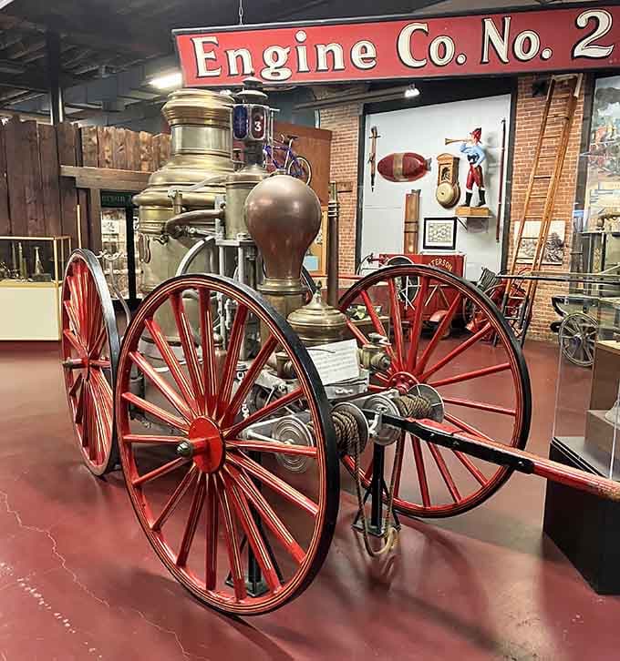 That gleaming brass steam fire engine with its bold red wheels looks ready to charge down the street right now.