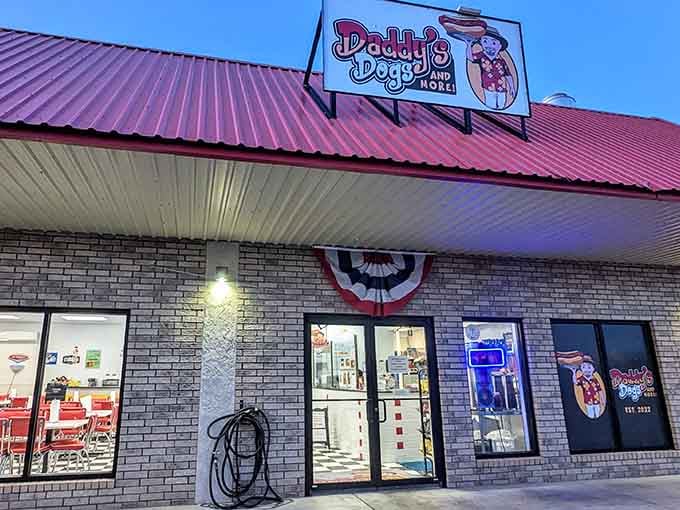 Daddy's Dogs and More glows warmly at dusk, its retro diner vibe and cheerful signage practically hollering "come on in, we saved you a seat."