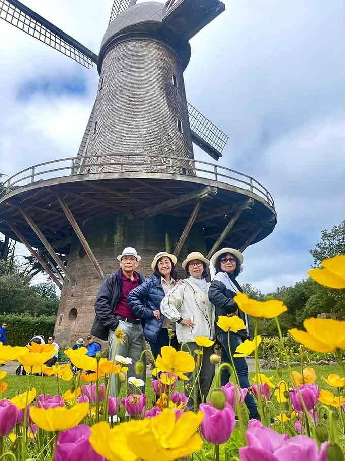 Four friends, one windmill, and a foreground full of yellow poppies. This is what a perfect afternoon looks like.
