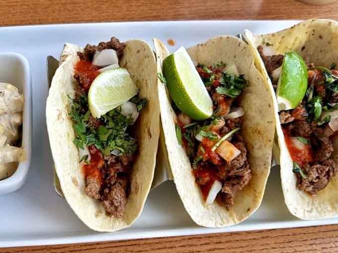 Three tacos lined up like they mean business, fresh cilantro, bright lime, and zero apologies.