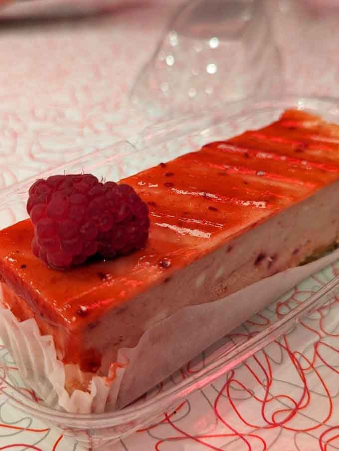 Creamy, glossy, and crowned with a fresh raspberry, this cheesecake slice means serious, unapologetic business.