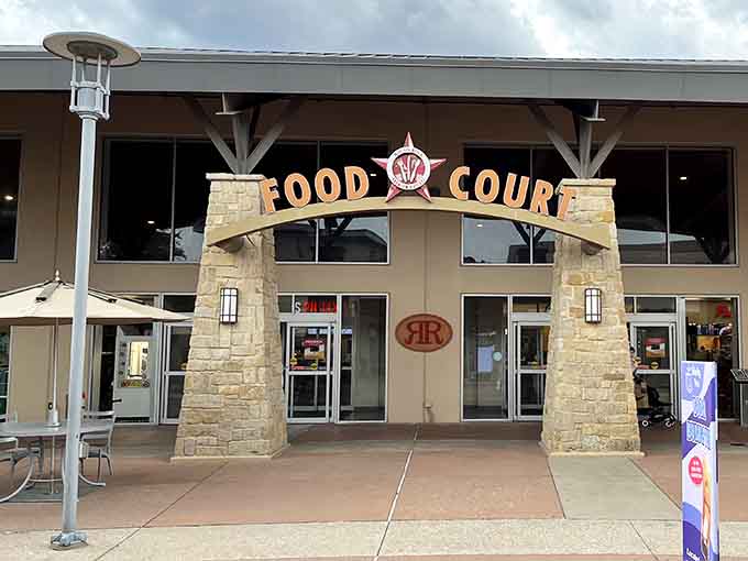 The food court entrance welcomes weary shoppers with open arms, because even bargain hunters need fuel for their retail marathons.