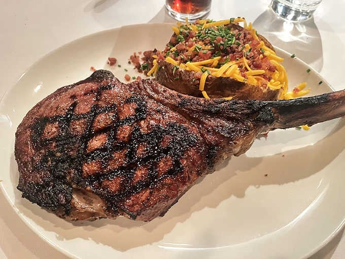 The USDA Prime Tom-A-Hawk Ribeye arrives at the table and immediately becomes the most interesting thing in the room.