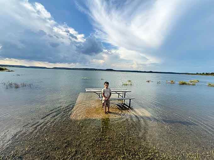 When the lake rises, even the picnic tables go for a swim, and this kid clearly approves.