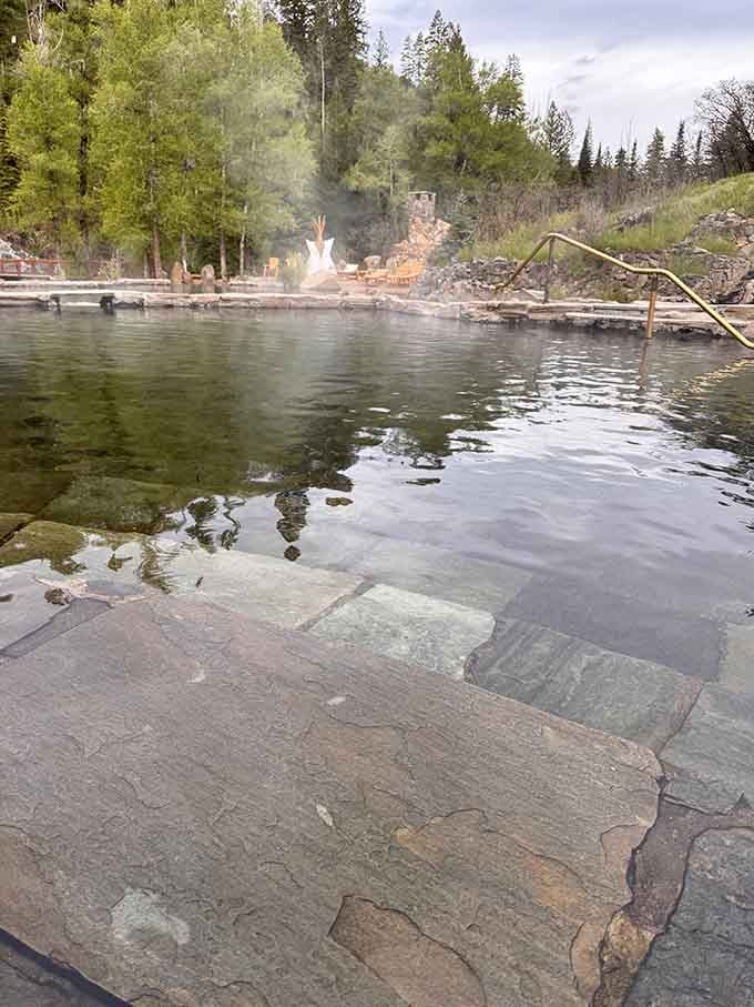 Stone steps disappearing into warm, steaming water, the kind of entrance that makes every other pool you've ever visited feel deeply inadequate.