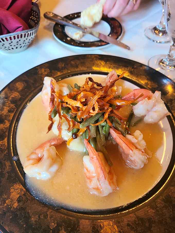 Plump shrimp nestled over green beans in a golden broth, topped with crispy onions for good measure.