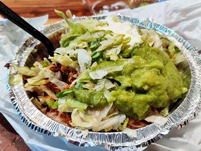 A generous pile of fresh toppings and guacamole that could make anyone reconsider their lunch plans entirely.
