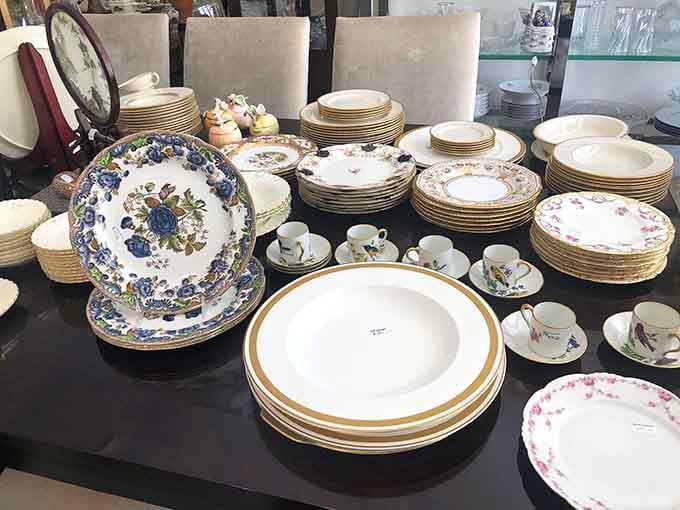 Fine china stacked with quiet dignity, each piece looking like it once graced a table set for very important guests.