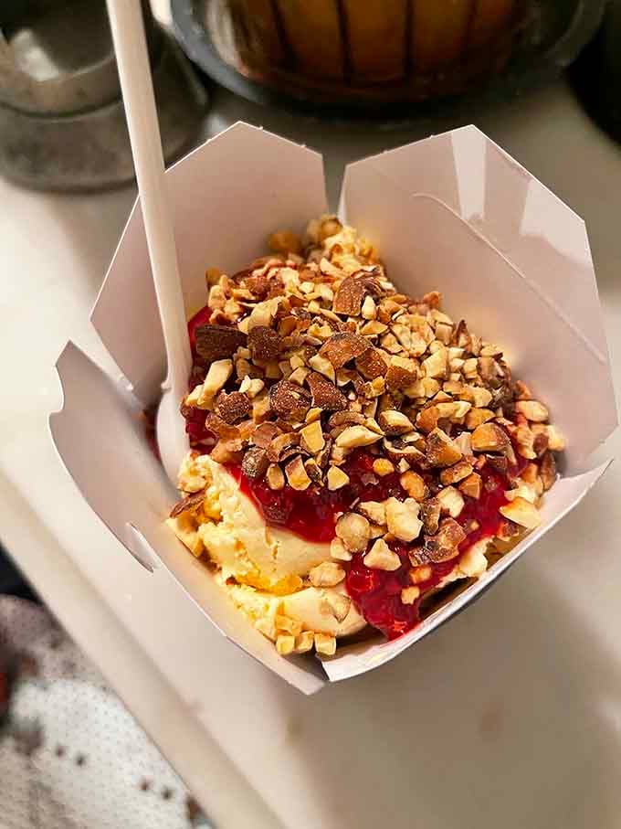 Vanilla ice cream, bright red fruit sauce, and a generous handful of chopped nuts, simple ingredients treated with genuine respect.