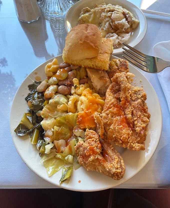 Crispy fried chicken, collard greens, pinto beans, mac and cheese, and cornbread together, this plate is basically a Southern greatest hits album.