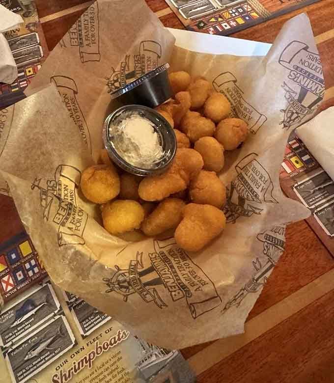 Golden hush puppies arrive like edible sunshine, perfectly crispy and dangerously addictive with every bite you take.