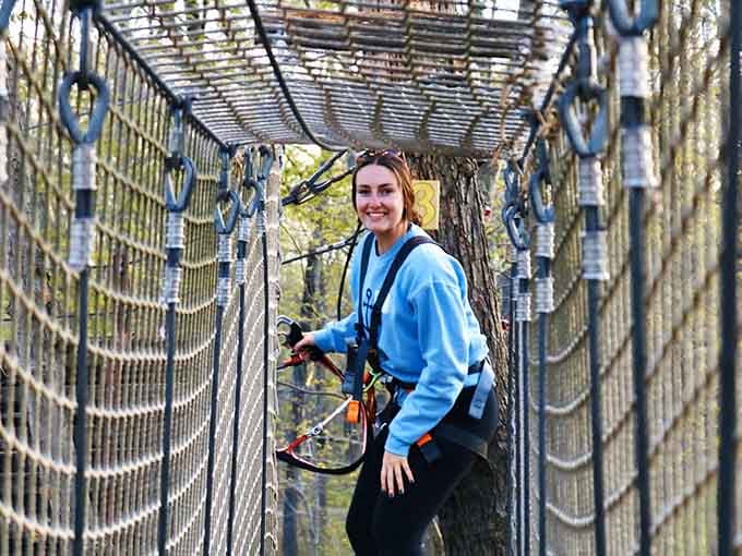 That smile says everything, navigating a rope tunnel high above the forest floor never gets old.