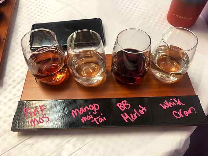 Four glasses lined up like old friends at a reunion: Pink Moscato, Mango Mai Tai, BB Merlot, and White Cranberry waiting patiently.