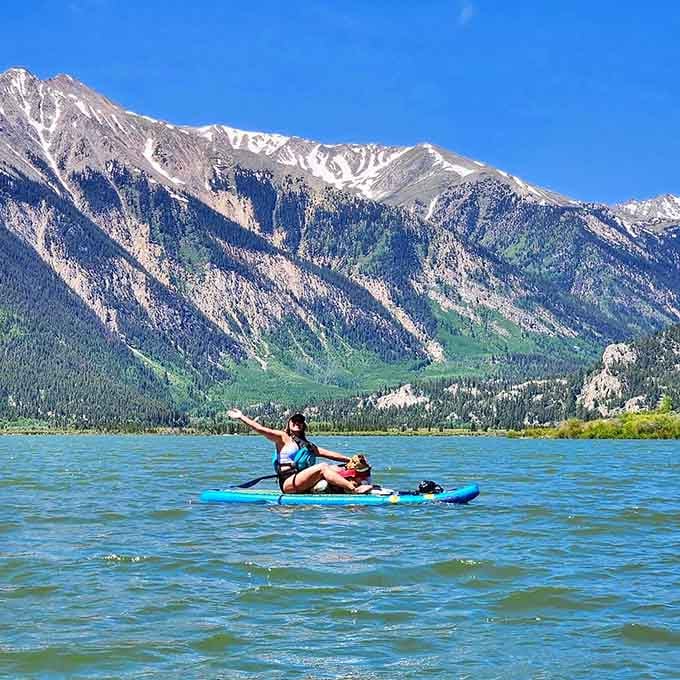 Paddleboarding with a dog co-pilot against a backdrop of towering peaks, because some days Colorado just refuses to be ordinary.