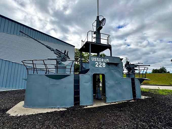 The USS Drum's conning tower stands guard on dry land, guns still pointed skyward like it hasn't gotten the memo yet.