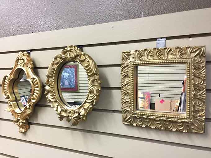 Three ornate gold-framed mirrors hanging side by side, because every hallway deserves a little old-world drama.