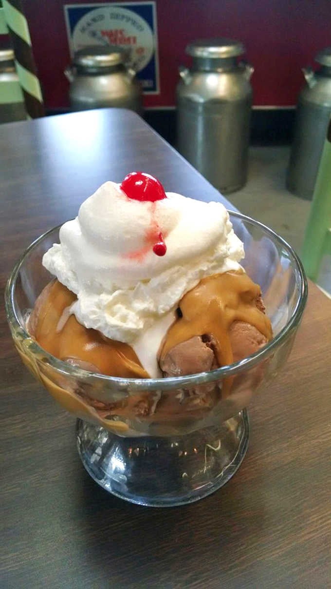 A classic sundae dressed to impress, with caramel, whipped cream, and a cherry that means business.