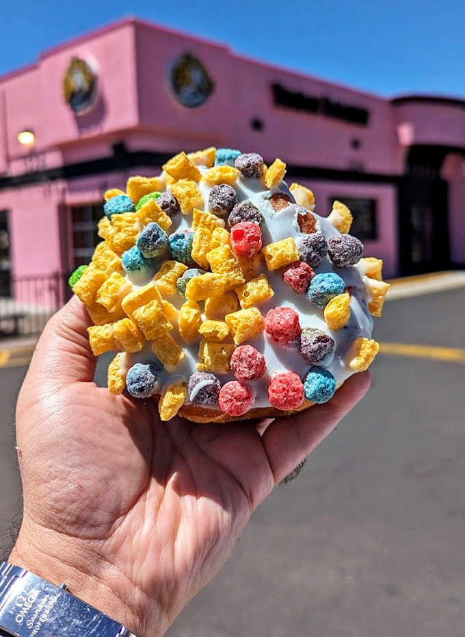 Captain Crunch on a donut, held against a pink building, is basically a modern masterpiece.