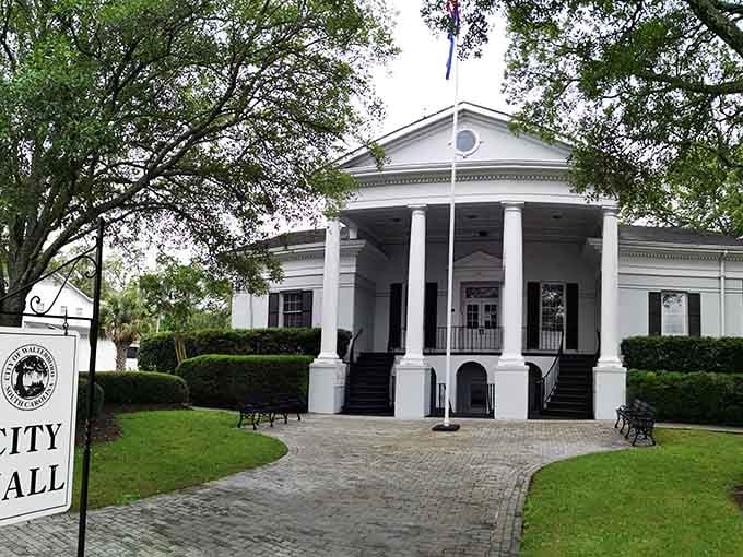 White columns, manicured hedges, and a flagpole standing at attention, small-town civic pride looking absolutely sharp.