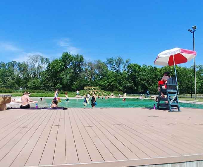 A lifeguard, a striped umbrella, and water so inviting it practically writes its own postcard home.