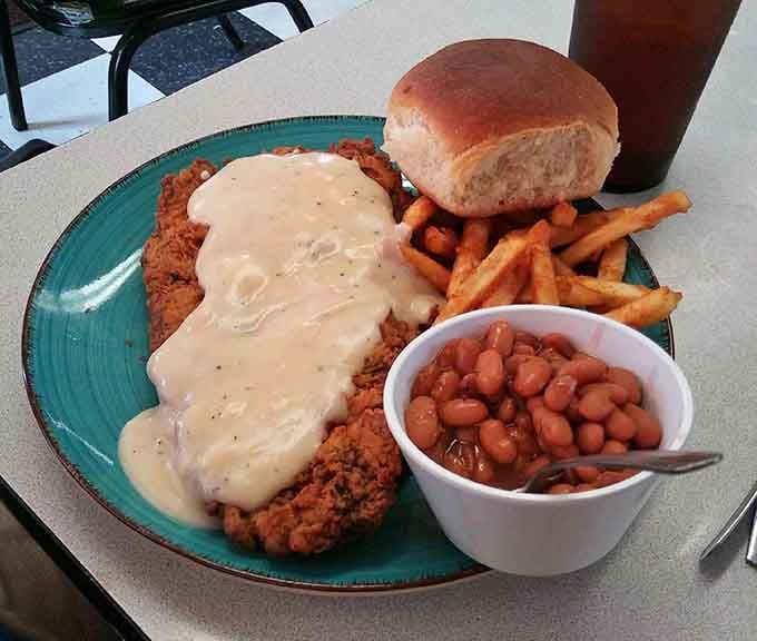 Chicken fried steak smothered in gravy with pinto beans and fries proves Texas knows what it's doing at mealtime.