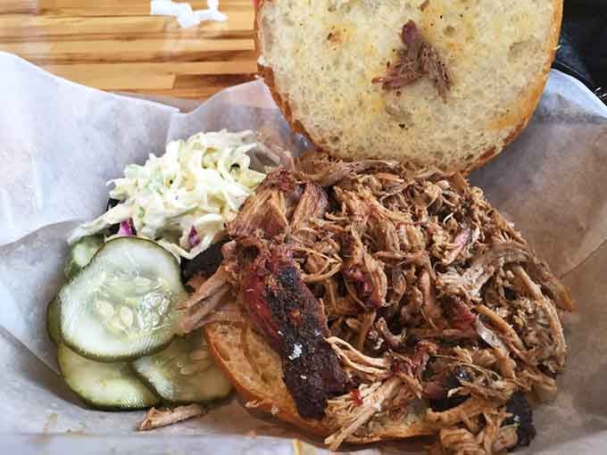 This pulled pork sandwich comes with pickles and coleslaw because even barbecue needs a supporting cast of characters.