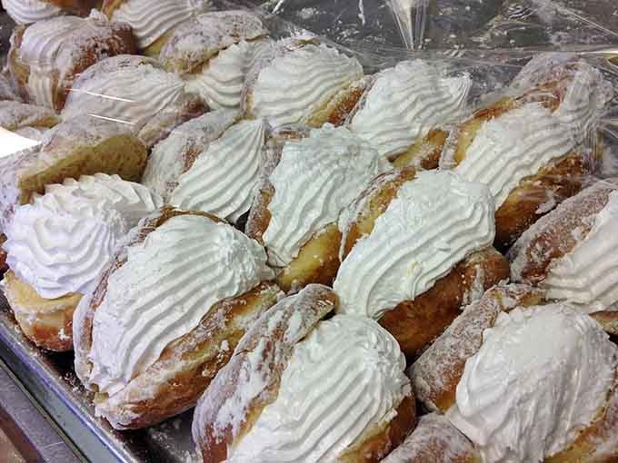 A whole tray of cream-filled donuts dusted in powdered sugar, because sometimes more is absolutely the right answer.