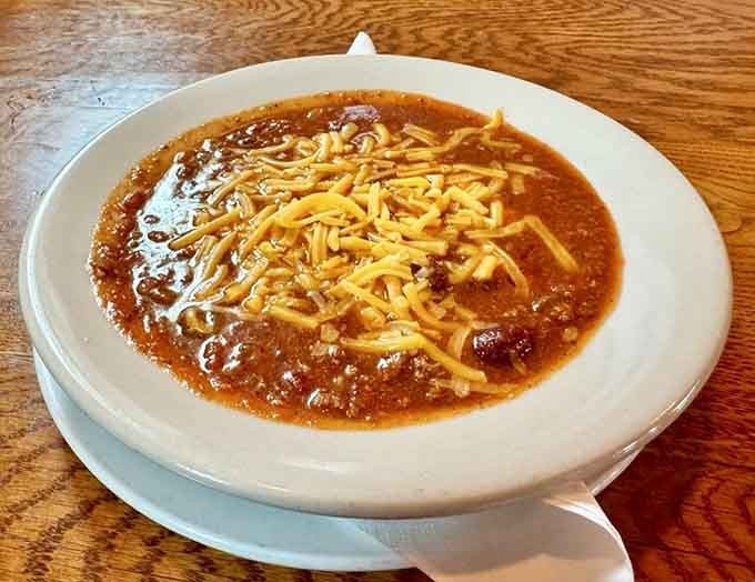 Chili topped with cheese because sometimes comfort food needs a blanket, and that blanket should be melted cheddar.