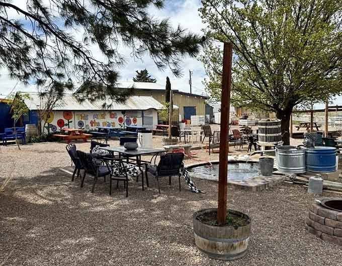 Mismatched chairs, a bubbling fountain, and barrel planters create a backyard gathering spot that feels genuinely joyful and alive.