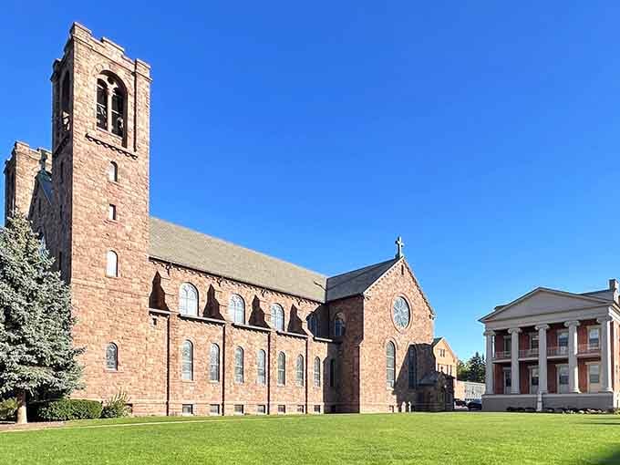 The stone church tower rises majestically against blue skies, anchoring a landscape of faith and architectural beauty.