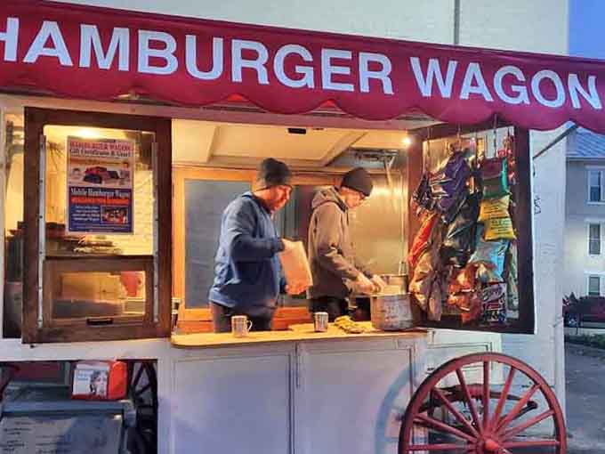 Two workers moving with quiet purpose under a warm glow prove that great burgers are always worth the cold.