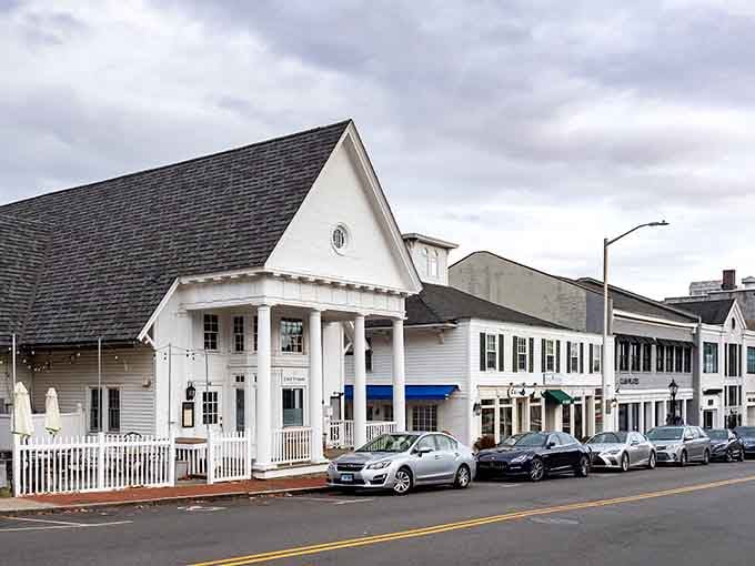 Crisp white columns and a picket fence frame this New Canaan storefront like a stage set designed by someone who truly loves New England architecture.