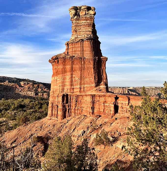 Palo Duro's famous Lighthouse formation stands tall against a brilliant blue sky, carved by wind and time into something unforgettable.