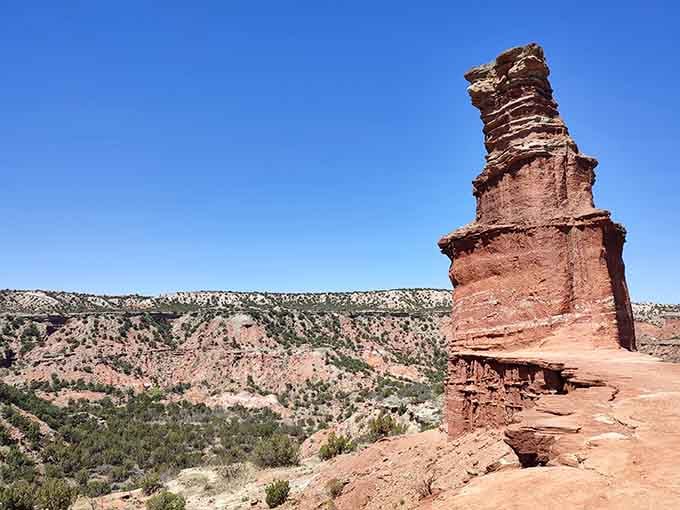 The Lighthouse formation stands tall against blue sky, a natural tower sculpted by wind into canyon country's most famous landmark.
