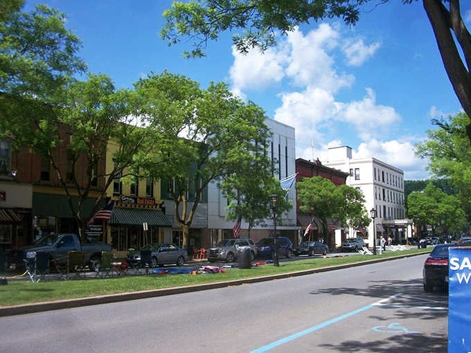 Tree-lined streets and historic buildings create shade and character in equal measure on sunny summer days.