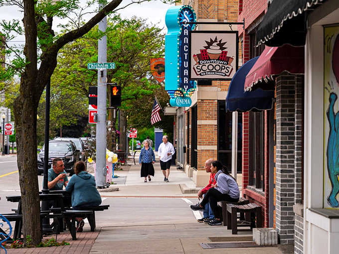 Chisholm Street in Alpena delivers pure downtown delight, where the Sanctuary Cinema marquee and Downtown Scoops sign promise a perfect afternoon ahead.