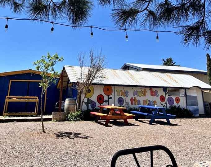 "This Must Be the Place" says the mural, and those colorful picnic tables under the string lights prove it.